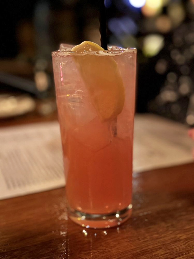 This rosy cocktail, garnished with a slice of citrus, promises refreshment that's both sophisticated and just a little bit naughty.