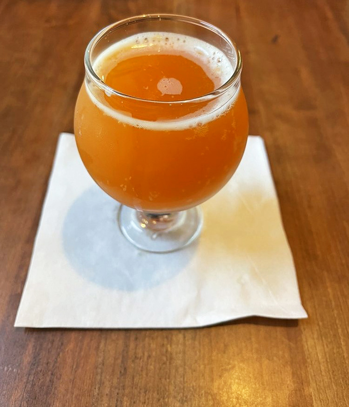 A golden craft beer catching the light just right &ndash; liquid sunshine in a glass, ready to complement those smoky flavors.