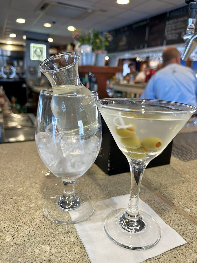 A perfectly chilled martini with olives standing at attention&mdash;the sophisticated companion to your seafood feast that whispers, "You've made excellent choices today."