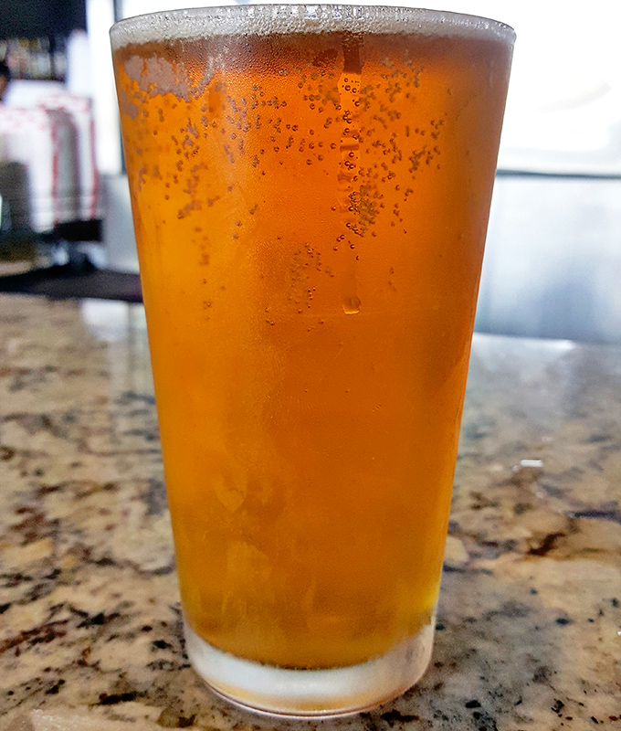 Even the beer looks happy to be here, golden and effervescent, ready to cool the pleasant burn of perfectly spiced barbecue.