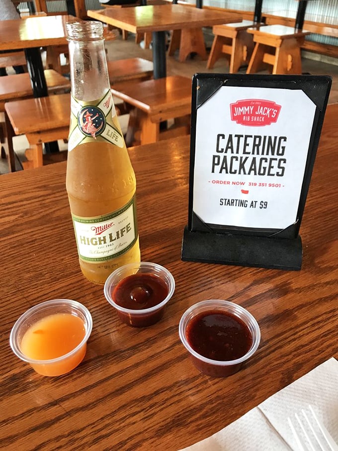 The holy trinity of barbecue sauces&mdash;each offering a different path to flavor enlightenment&mdash;alongside a cold beer for proper decision-making.