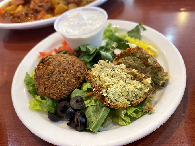 Golden falafel sitting on fresh greens like crispy little flavor bombs that actually deliver on their promise.