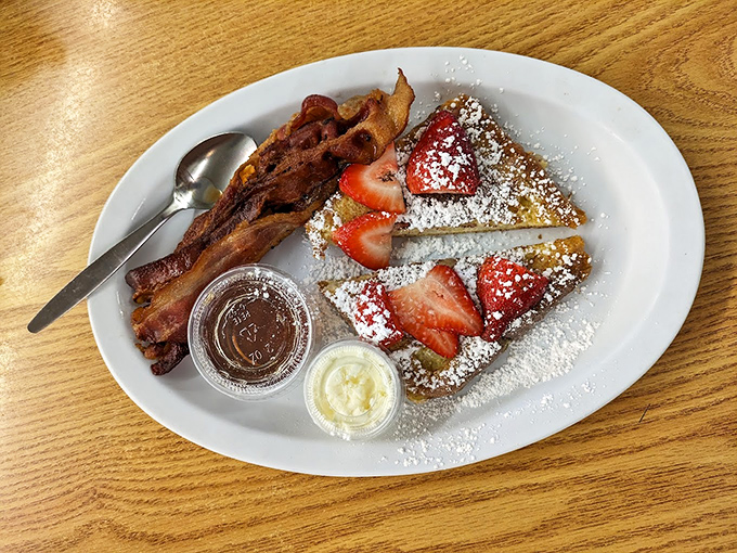 French toast that's dressed for success with powdered sugar, fresh strawberries, and bacon that's achieved that perfect crisp-chewy balance.