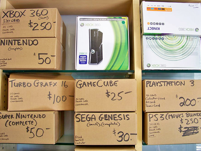 Gaming history stacked in cardboard time machines. From SEGA Genesis to PS3, yesterday's cutting-edge technology awaits nostalgic fingers.