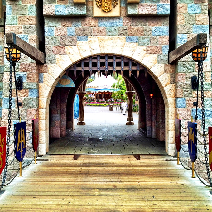 The castle drawbridge welcomes adventurers through an archway where medieval fantasy meets California sunshine.