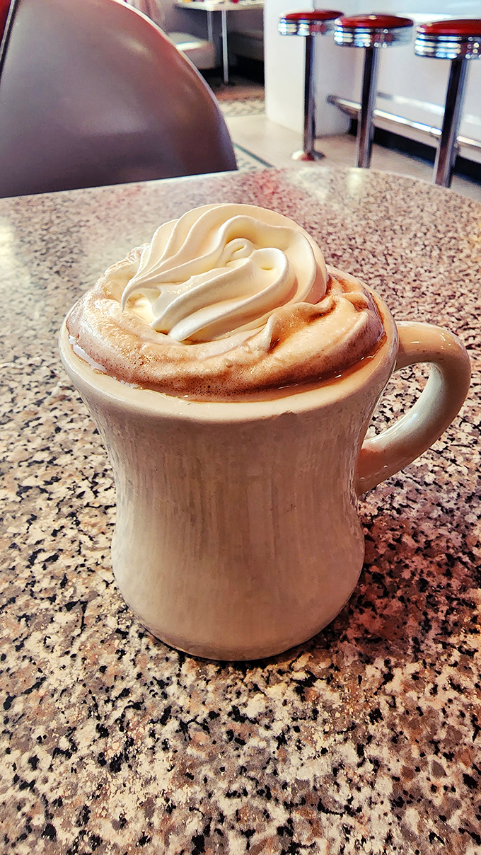 Not your average gas station coffee. This whipped cream mountain atop steaming hot chocolate transforms morning caffeine into dessert-worthy decadence.
