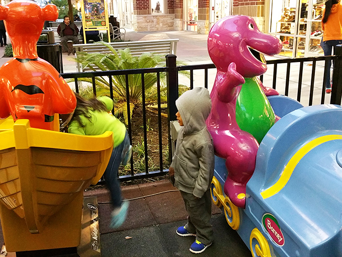 The children's play area features a purple dinosaur that seems to say, "You shop, I'll entertain the little ones until they're ready for their own credit cards."