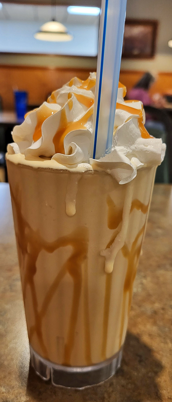 A milkshake thick enough to bend straws and challenge spoons, drizzled with caramel that cascades like a sweet waterfall.