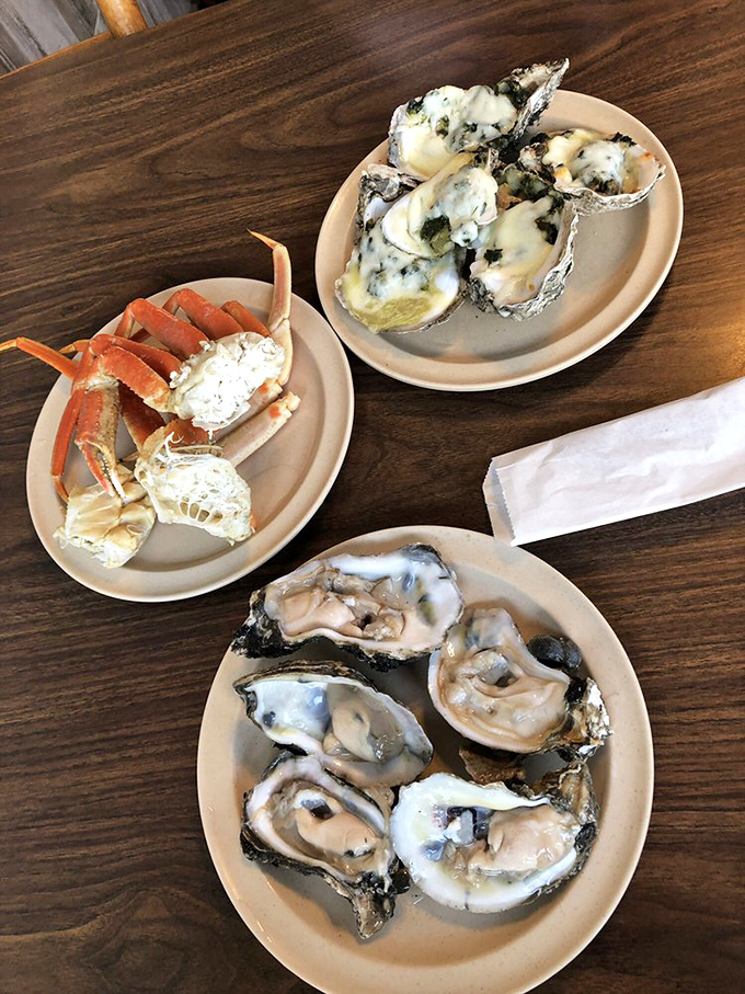 The holy trinity of shellfish: raw oysters, crab legs, and baked oysters. This plate represents the ocean's finest gifts, presented with reverent simplicity.