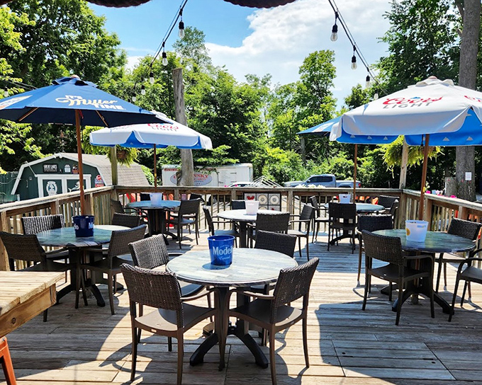 The outdoor patio offers a sun-dappled retreat where cold drinks taste even better under blue umbrellas and the gentle rustle of lakeside breezes.