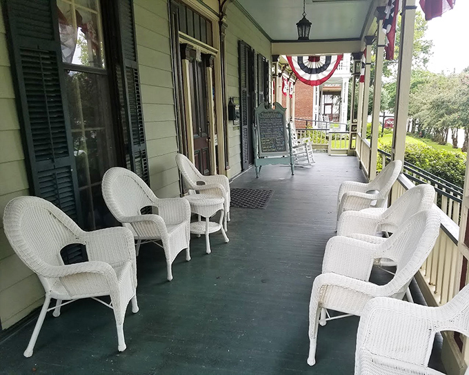 The front porch at Walnut Hills isn't just a waiting area—it's where sweet tea sipping and gentle rocking chair conversations happen before and after your meal.