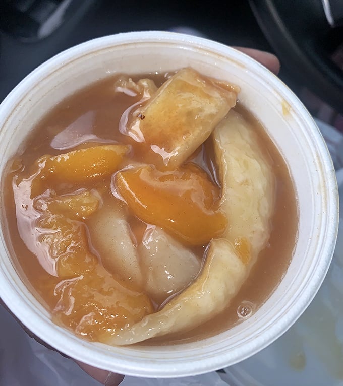 Peach cobbler that's not just dessert but a warm, sweet hug in a cup, with fruit and pastry dancing together in perfect harmony.