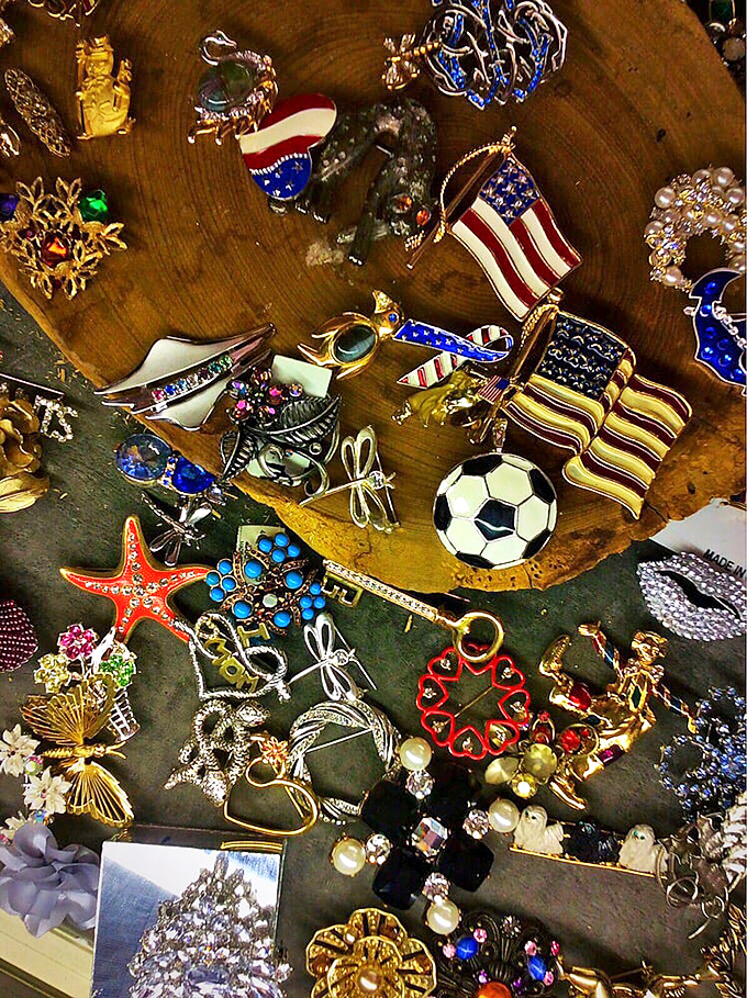 A wooden platter becomes a gallery for miniature treasures&mdash;patriotic pins nestled alongside whimsical charms. Tiny art for your lapel.