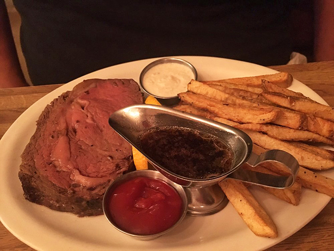 Prime rib cooked to that perfect shade of pink that makes meat lovers go quiet for a moment. The au jus boat is basically a gravy yacht.