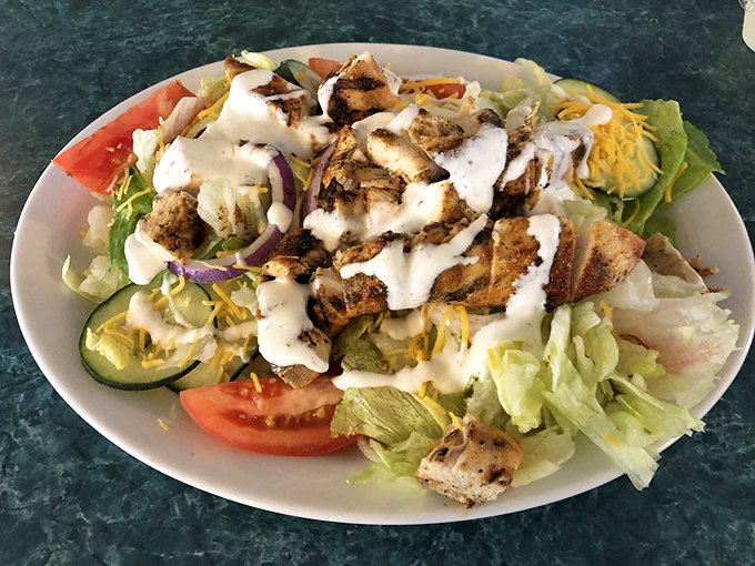 Fresh greens playing the supporting role to perfectly grilled chicken—proof that salads don't have to be punishment for dietary sins.