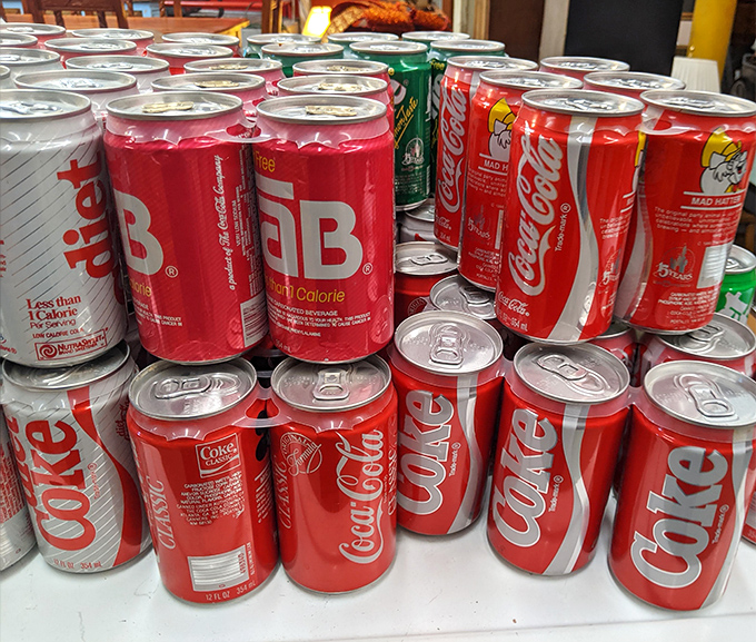Vintage soda cans arranged like a fizzy museum exhibit – remember when Tab was revolutionary and Coca-Cola cans had that distinctive shape?
