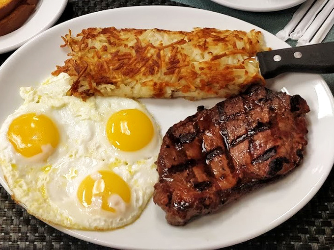The holy trinity of breakfast: perfectly cooked eggs, a steak with beautiful grill marks, and hash browns crisped to golden perfection.