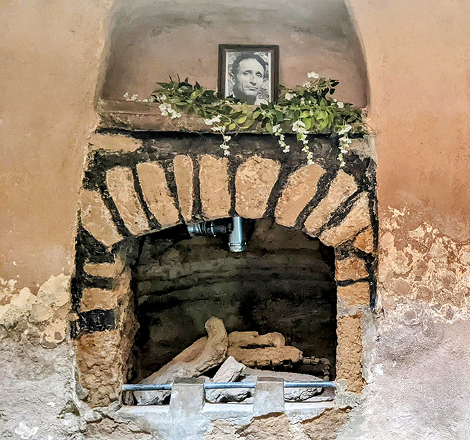 A handmade fireplace built into the rock walls, because underground living still requires warmth, cooking, and cozy evening ambiance.