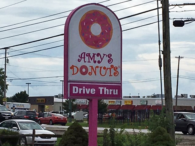 The roadside sign announces not just a drive-thru but a 24/7 commitment to satisfying your donut emergencies at any hour.