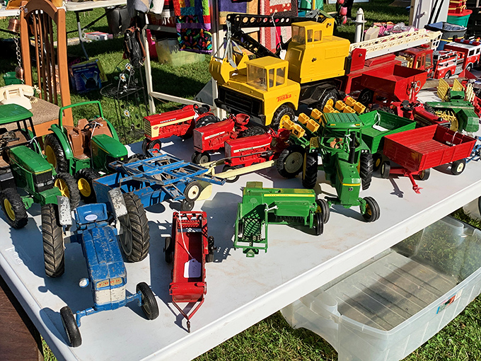 A miniature farm equipment convention where John Deere green dominates. Every Wisconsin child's sandbox dreams lined up in perfect, collectible rows.
