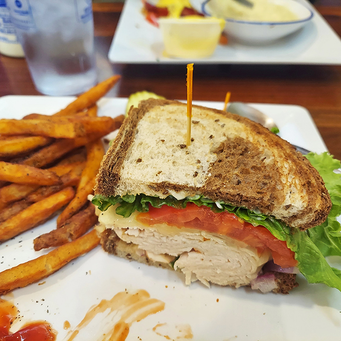 This turkey sandwich isn't just lunch&mdash;it's architecture. Layers of fresh ingredients stacked between toasty bread with sweet potato fries standing guard.