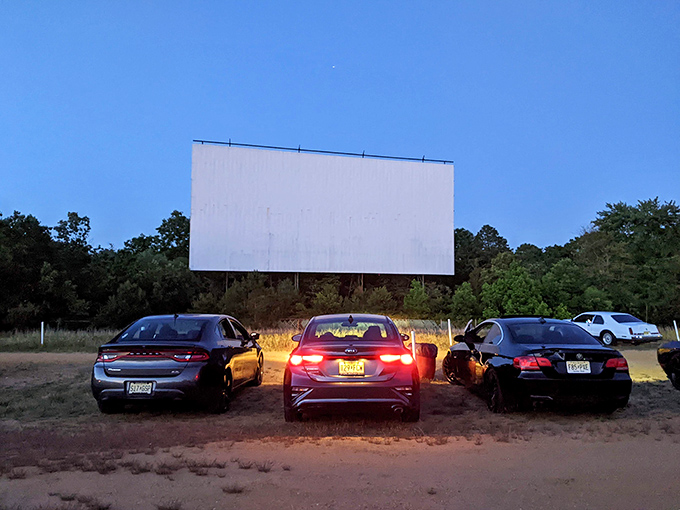 As twilight approaches, cars find their perfect viewing spots. The anticipation builds&mdash;a communal experience that's somehow both public and intimate.
