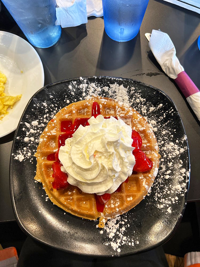 A waffle adorned with strawberries and whipped cream&mdash;proof that sometimes the simplest pleasures are the most profound. Breakfast as art.