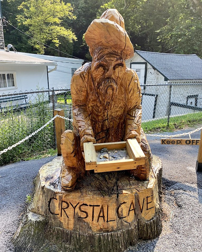 A wooden wizard guards his crystal treasure &ndash; this carved statue captures the magical feeling of discovering underground wonders.