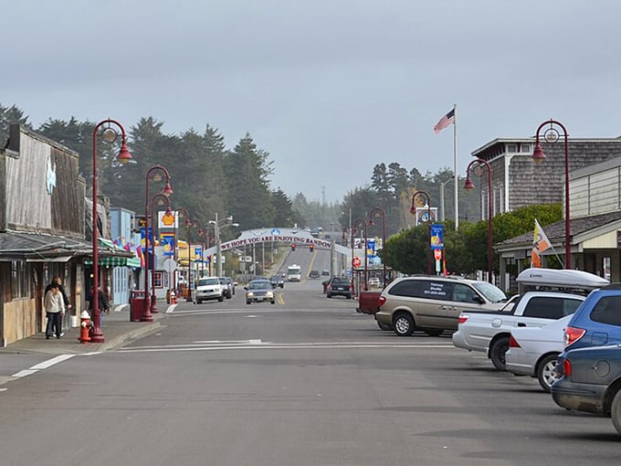 Bandon's charming main street welcomes visitors with colorful storefronts, decorative lampposts, and a misty coastal atmosphere typical of Oregon's seaside towns.