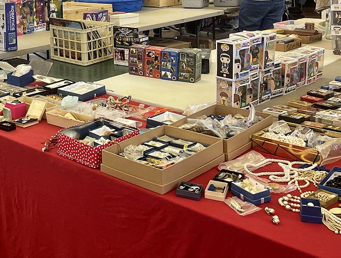 Sparkle spectacular! Pearls and baubles lounging on red velvet like tiny celebrities, while Funko Pop figures stand guard over this treasure chest of wearable bling.