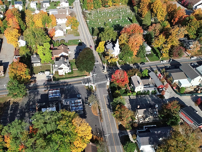 Autumn paints the treetops in brilliant yellows and oranges while the town below goes about its business, blessed by nature's annual masterpiece.