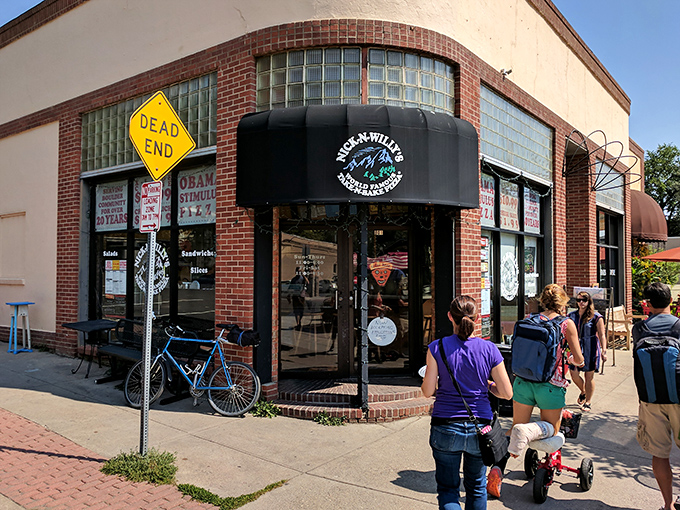 Brick and glass storefront beckons with promises of creative toppings and college town charm.