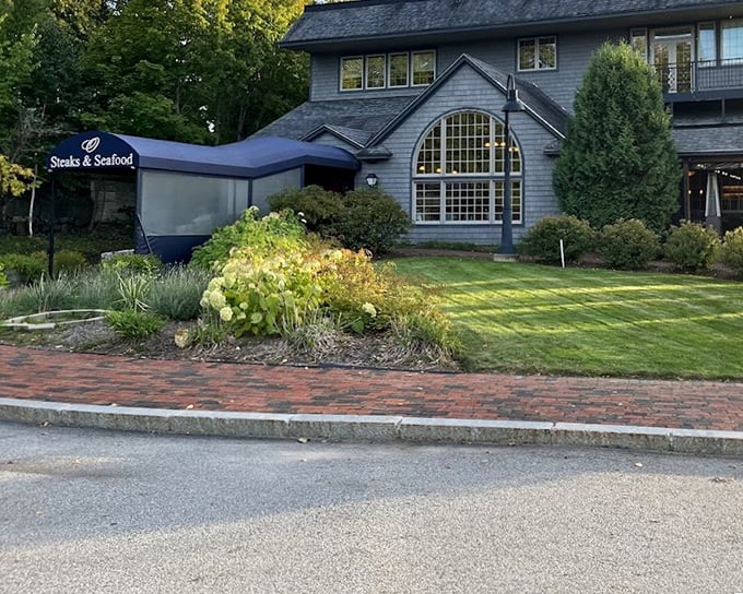 Manicured landscaping and that distinctive arched window suggest a restaurant where presentation matters as much as the perfectly grilled ribeye.