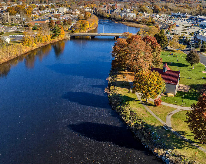 Sapphire waters mirror autumn's golden tapestry while a charming red barn anchors this budget-friendly riverside paradise.
