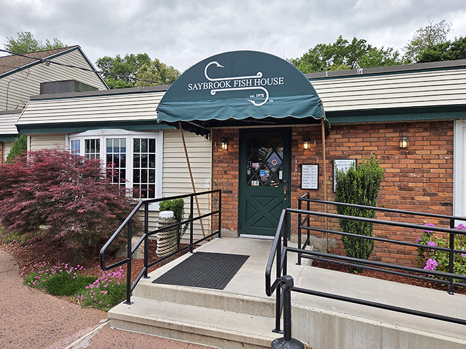 The Saybrook Fish House entrance promises seafood comfort in a world of culinary chaos. That green door leads to happiness.
