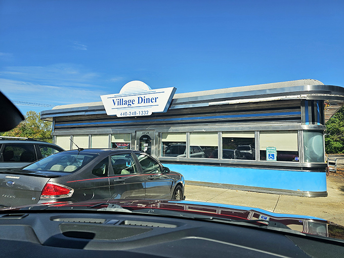 The Village Diner's curved chrome edges and blue accents whisper stories of first dates and Saturday morning pancakes.