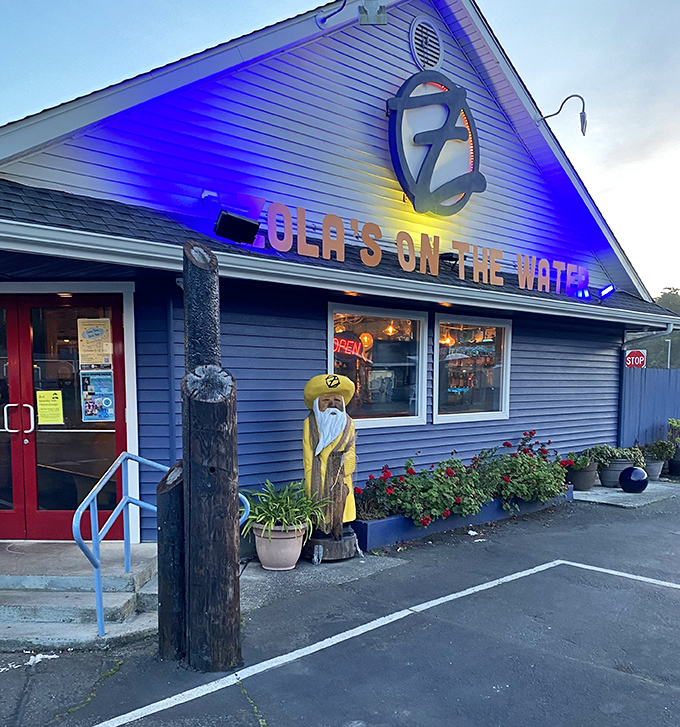 Blue building by the harbor where ocean breezes and wood-fired ovens create coastal pizza magic daily.