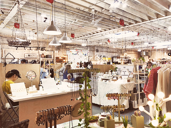 White-painted rafters and pendant lights create a modern backdrop for vintage treasures displayed with care and artistic intention.