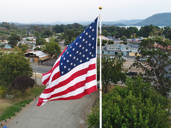 Stars and stripes wave over a lakeside town where patriotic values include keeping the American Dream financially accessible.