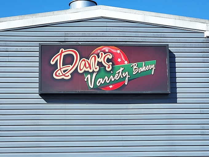 The retro charm of Dan's Variety Bakery sign glows against the blue siding. A portal to simpler, sweeter times.