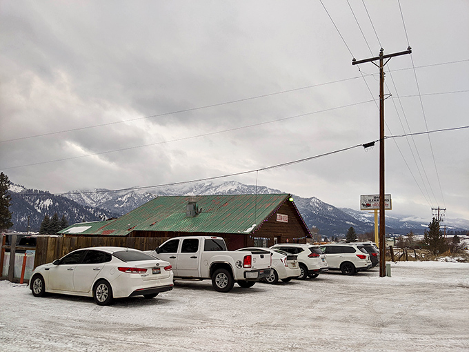 Winter transforms this peaceful valley into a snow-globe scene, where cozy buildings offer refuge from mountain storms.