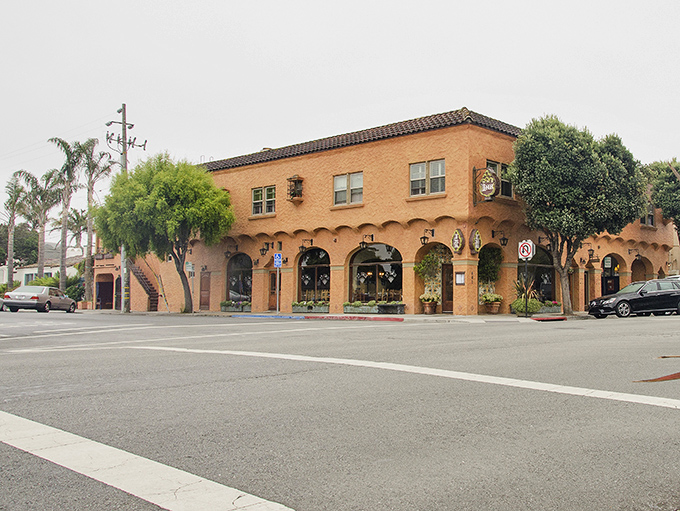 The Mediterranean heart of the town. With its arched windows, terracotta stucco, and tile roof, this building anchors the corner with a beautiful touch of classic California Mission Revival style.