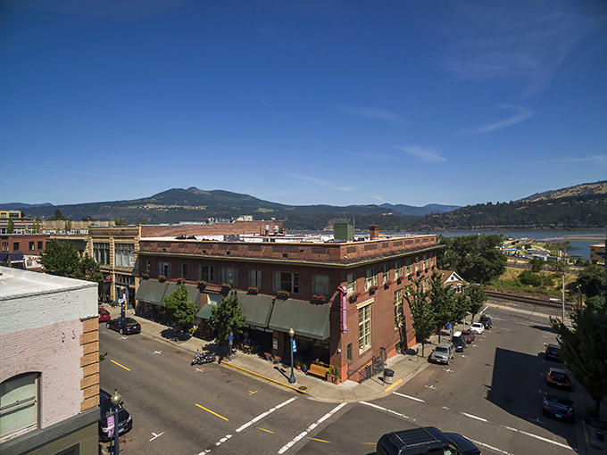 Hood River's main street invites you to stroll past brick buildings while the Columbia River glistens in the distance like nature's own welcome sign.