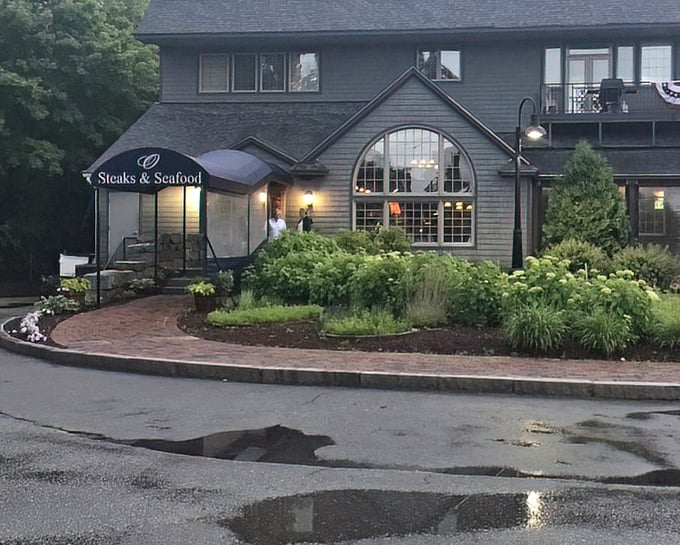 Evening lights reflecting on pristine grounds create an atmosphere that says "special occasion dining" before you even taste the first bite.