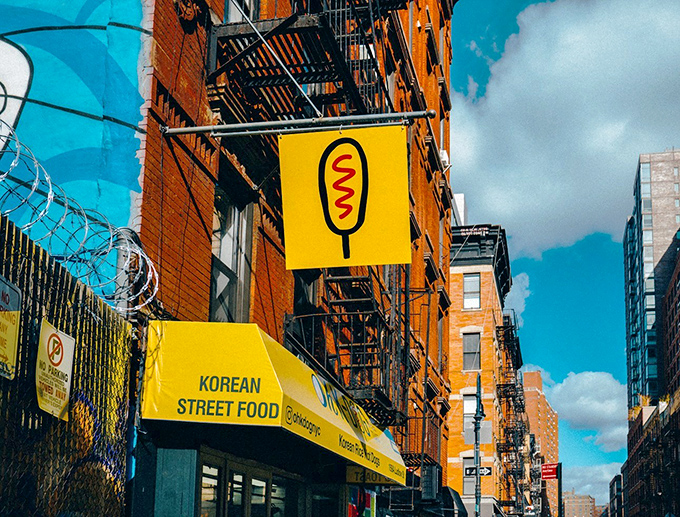That bright yellow awning signals where traditional hot dogs get an exciting international makeover worth celebrating.