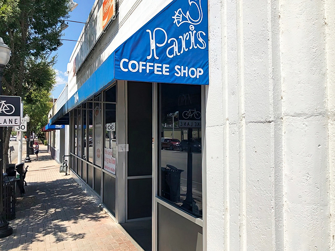 The sidewalk view of Paris Coffee Shop invites you to slow down and remember when coffee wasn't something you ordered while sprinting.