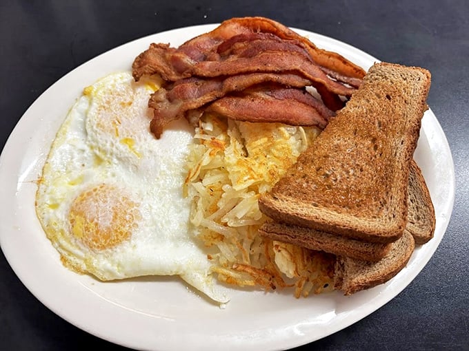 The classic American breakfast trinity: perfectly cooked eggs, hash browns with the ideal crisp-to-tender ratio, and bacon that makes you forget cholesterol exists.