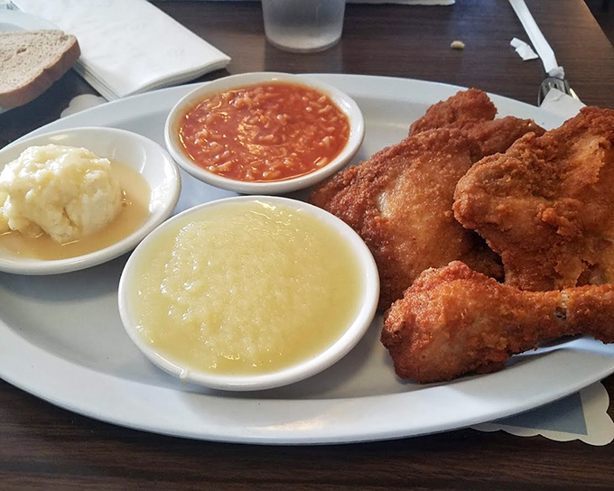 A plate that proves dark meat deserves the spotlight &ndash; juicy thighs alongside that signature hot sauce, applesauce, and mashed potatoes create the comfort food trifecta.