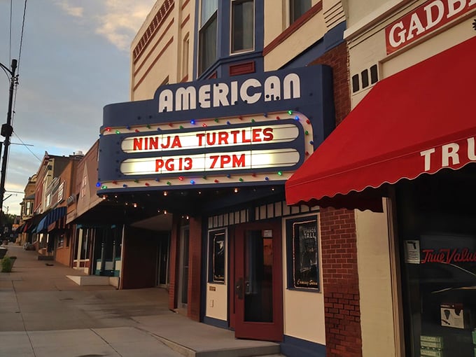 The American Theatre's neon marquee glows at dusk, promising cinematic escapes without the astronomical prices of multiplexes.