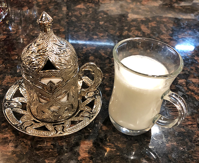 Traditional ayran served in ornate glassware. This tangy yogurt drink might challenge Western palates, but culinary adventurers know it's the perfect complement to spiced dishes.